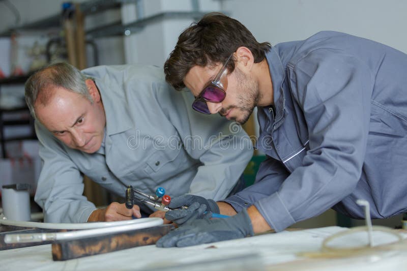 Two men working on machine stock photo. Image of operative - 309079768