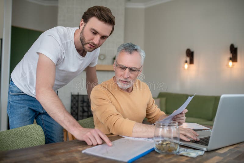 Two Men Working Together on a Project and Looking Involved Stock Photo ...