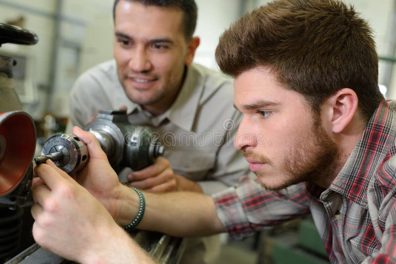 Two Men Working Together To Operate Machine Drill Stock Image - Image ...