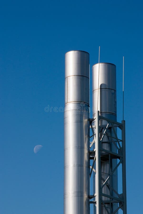Two Metal Chimneys on the Roofs of Factory. Against Blue Sky Stock ...
