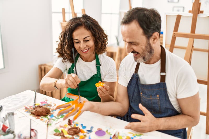 Two Middle Age Student Smiling Happy Painting Hands at Art Studio Stock ...