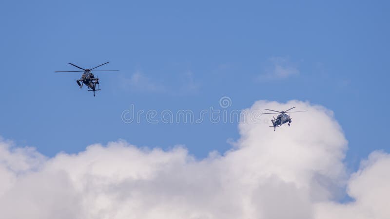 Two Military Helicopters Flying Against a Beautiful Sky with Clouds ...