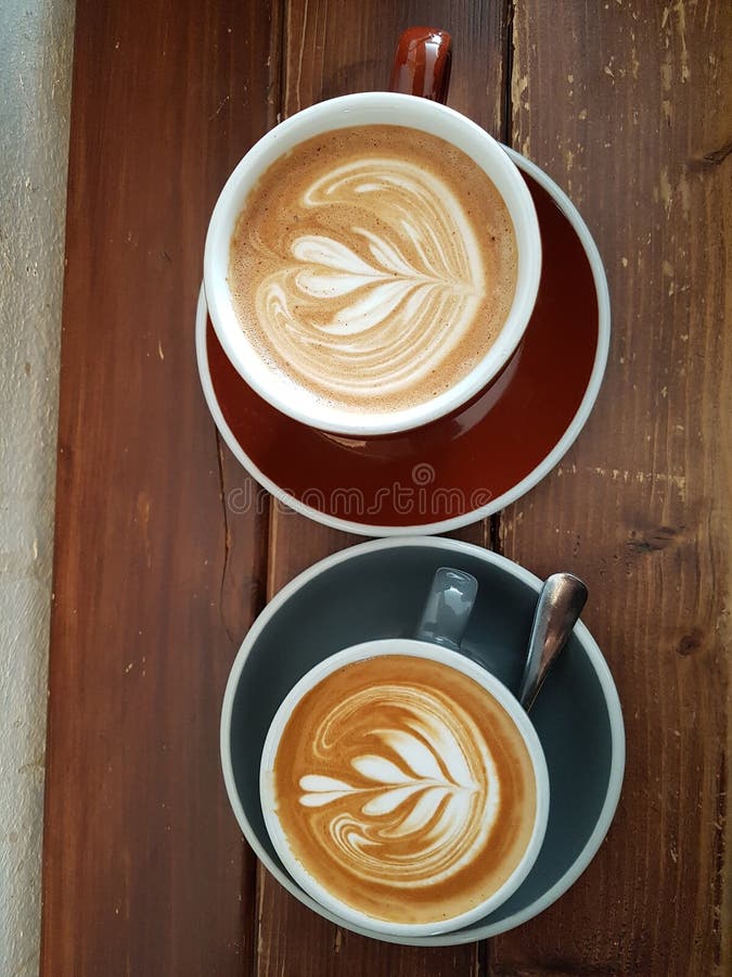Two Milk Coffees in the Shape of a Tree in a Cup on a Wooden Table ...