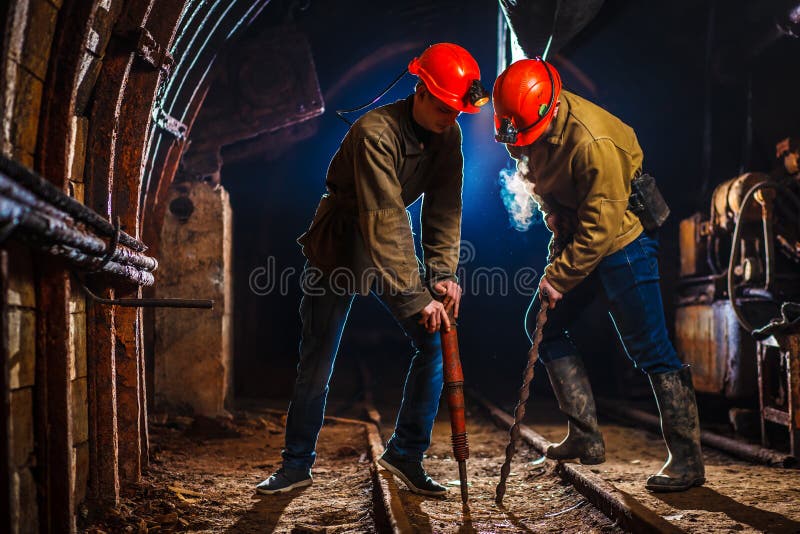 A Miner in a Coal Mine Stands Near a Trolley. Copy Space. Passages and ...