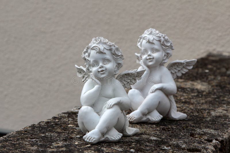 Two Miniature Angels on a Stone Wall Stock Photo - Image of angels ...