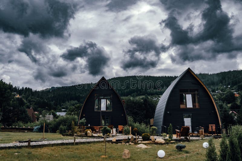 Two Modern a-frame Cabins Sit Side by Side Under a Dramatic, Stormy Sky ...