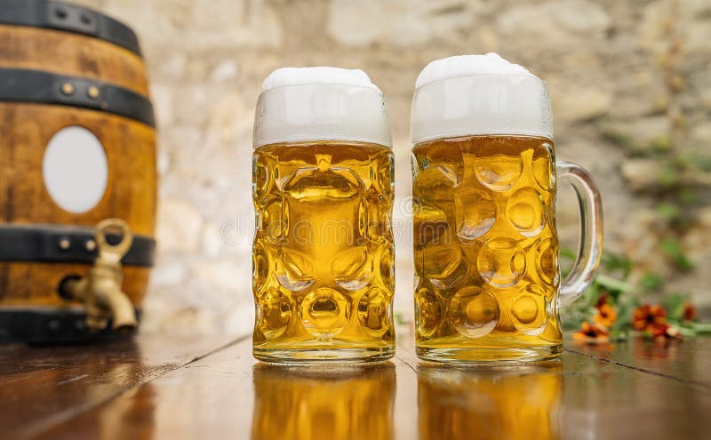Two Mugs of Beer with Foam Stand on the Table with Wooden Barrel Stock ...