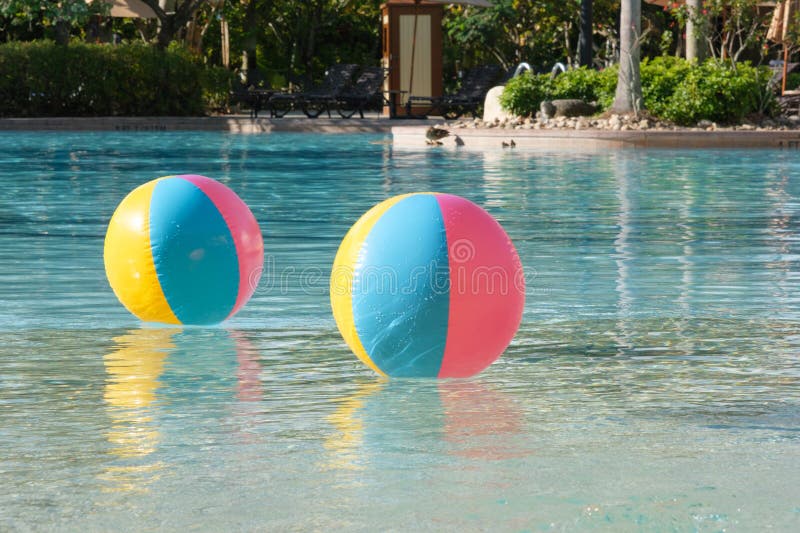 Two Multi-colored Beach Balls Float in the Water of a Resort Swimming ...