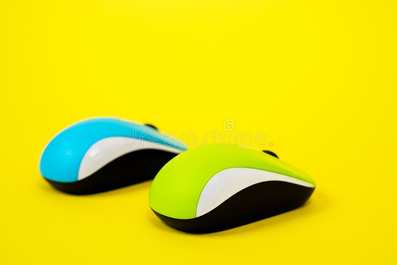 Two Multi Colored Computer Mice Lie Next To Each Other on Yellow ...
