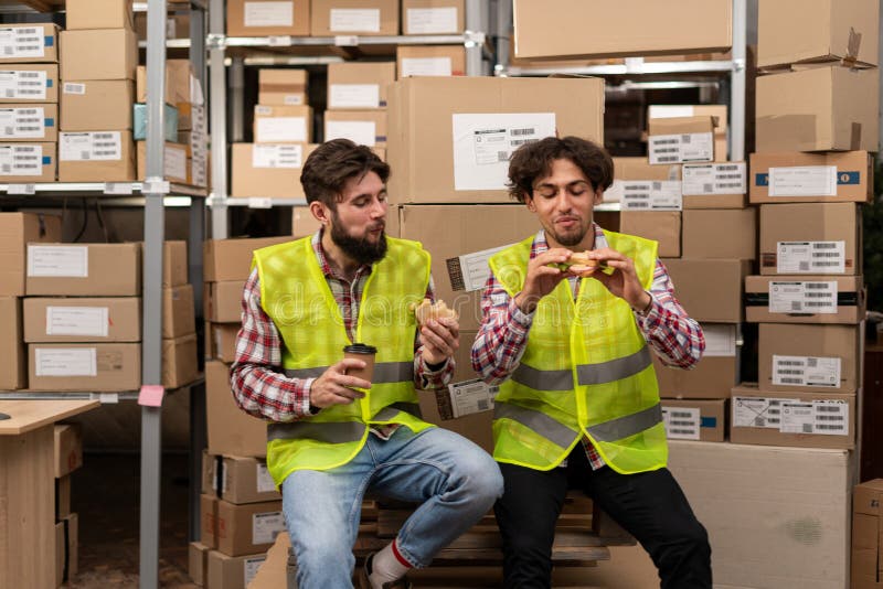 Two Multi Ethnic Workers Sitting in Warehouse Environment and ...