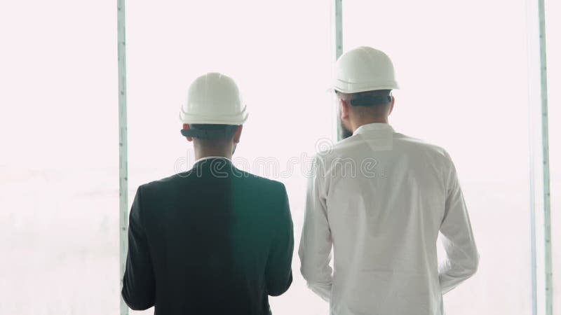 Two Multiethnic Builders Engineers Workers in Helmets Walking on ...