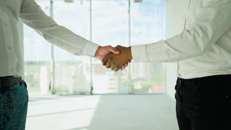 Two Multiethnic Builders Shaking Hands on Construction Site. Handshake ...