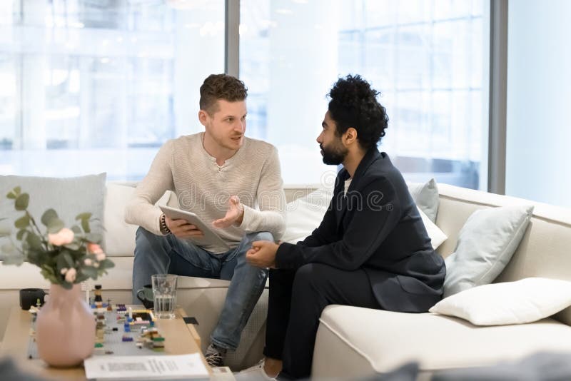 Two Multiethnic Business Colleagues Discussing Work Tasks Office Couch ...