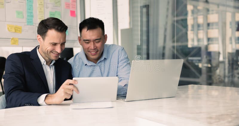 Two Multiethnic Workmates Review Agenda, Presentation, Relevant ...