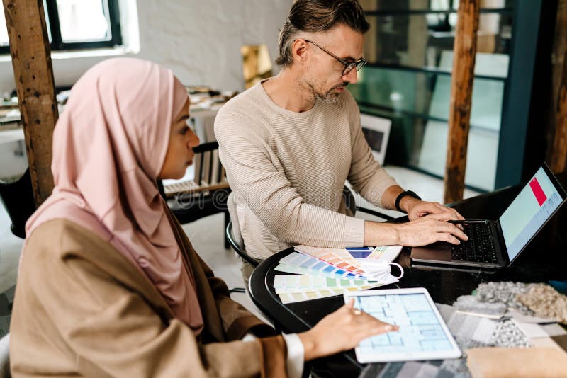 Two Multinational Colleagues Working with Computers Together in Office ...