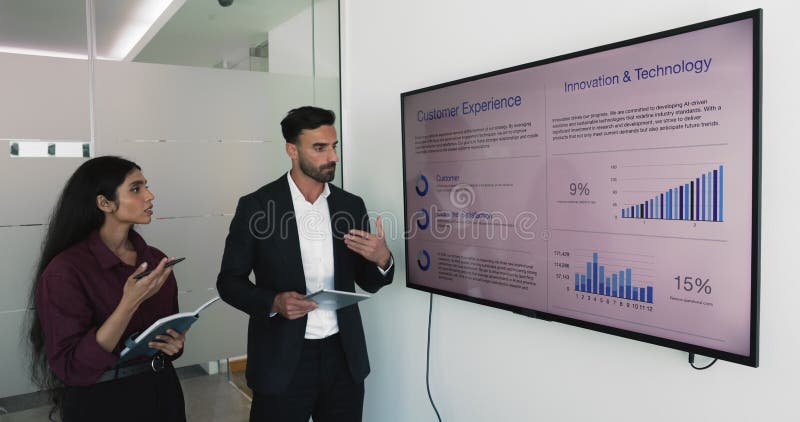 Two Multinational Teammates Review Presentation Slides Displayed on ...