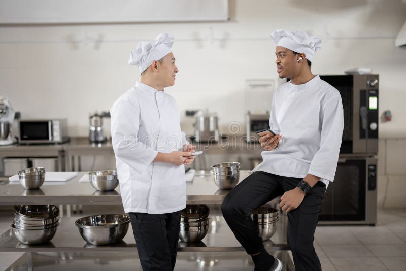 Two Multiracial Chef Cooks Talking during a Break at the Professional ...