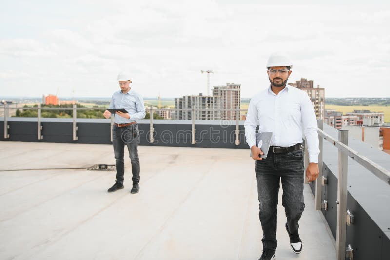 Two Multiracial Engineer Working at Site of a Large Building Project ...