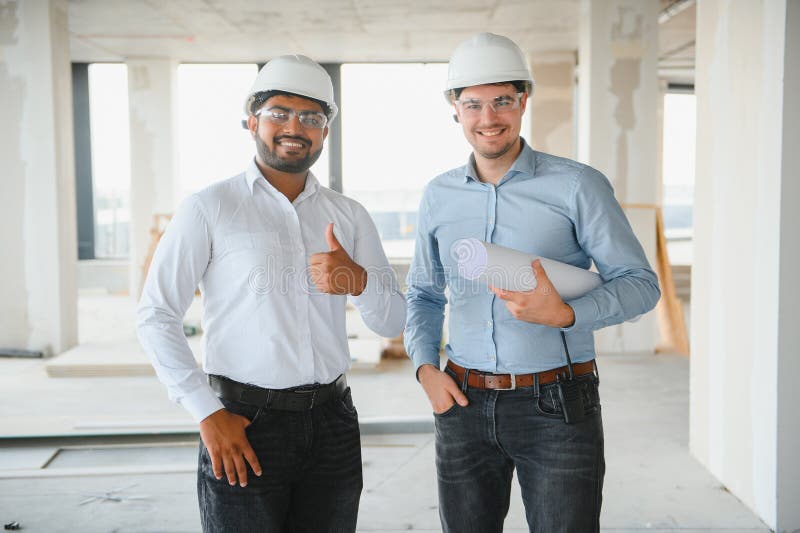 Two Multiracial Engineer Working at Site of a Large Building Project ...