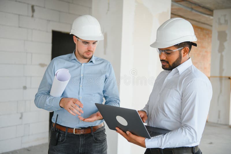Two Multiracial Engineer Working at Site of a Large Building Project ...