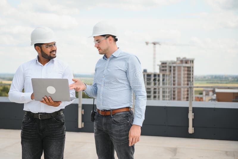 Two Multiracial Engineer Working at Site of a Large Building Project ...