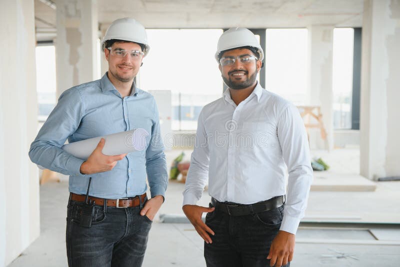Two Multiracial Engineer Working at Site of a Large Building Project ...