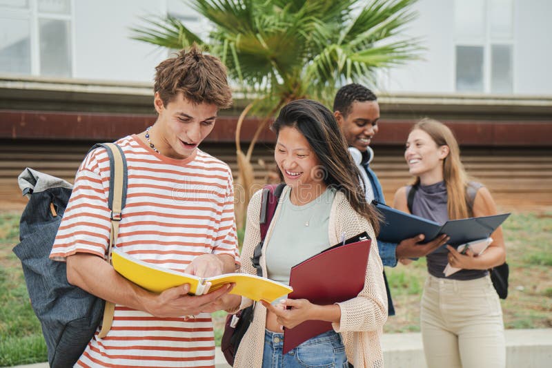 Two Multiracial Students Review Their Class Notes in a Notebook while ...