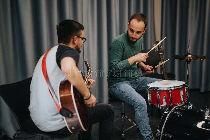 Two Musicians Collaborating in a Studio Space Playing Guitar and Drums ...