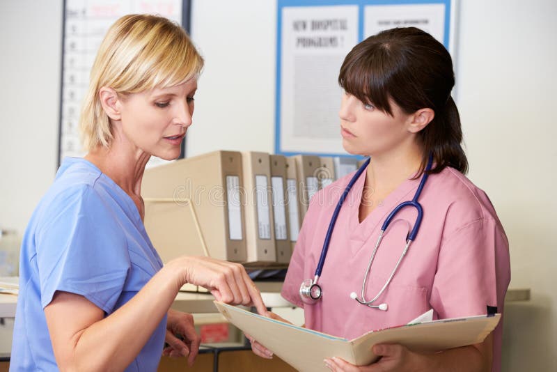 Two Nurses Discussing Patient Notes at Nurses Station Stock Image ...