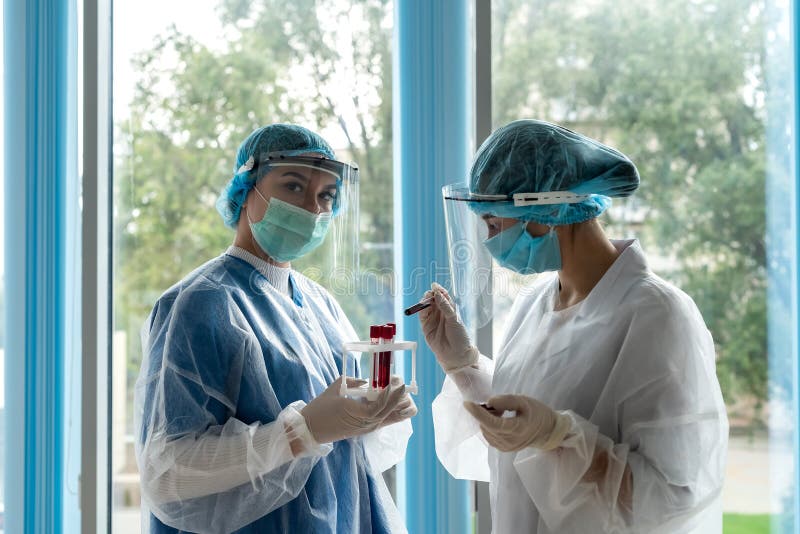 Two Nurses Work with Blood Samples To Determine the Outcome of a ...