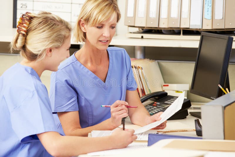 Two Nurses Working at Nurses Station Stock Image - Image of friendly ...
