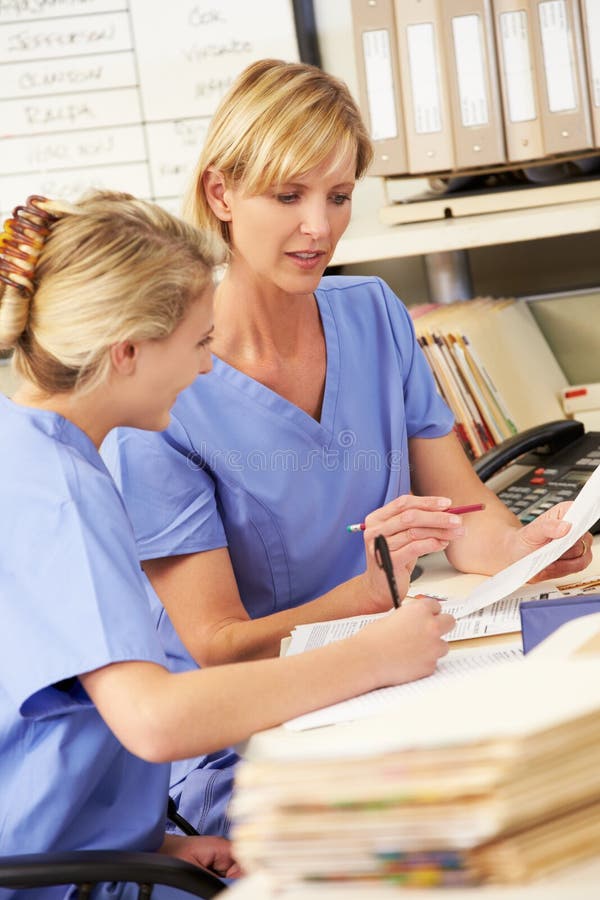 Two Nurses Working at Nurses Station Stock Image - Image of camera ...