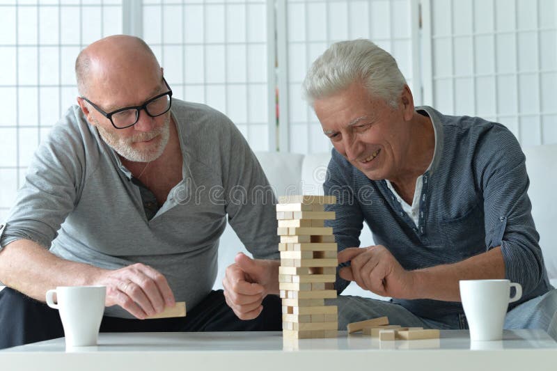 Two Old Men Sitting at Table and Playing with Wooden Blocks Stock Photo ...