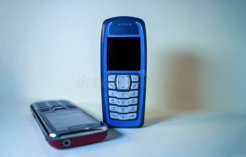 Two Old Mobile Phone or Cellular Device with Physical Button on a Grey ...