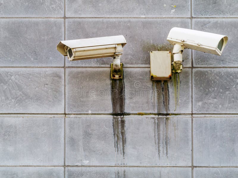 Two Old Security Cameras on a Grey Stone Wall of a Building. Security ...