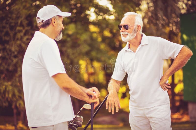 Older Men Stand on a Golf Course and Talk Stock Image - Image of ...
