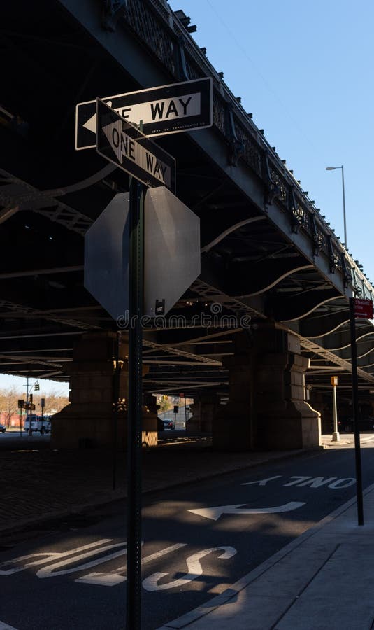 Two `One Way` Signs Intersecting Under a Bridge in Dramatic Light Stock ...