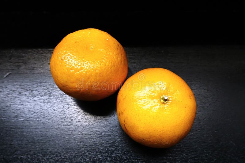 Two Oranges on a Black Surface Wood Background. Stock Photo - Image of ...