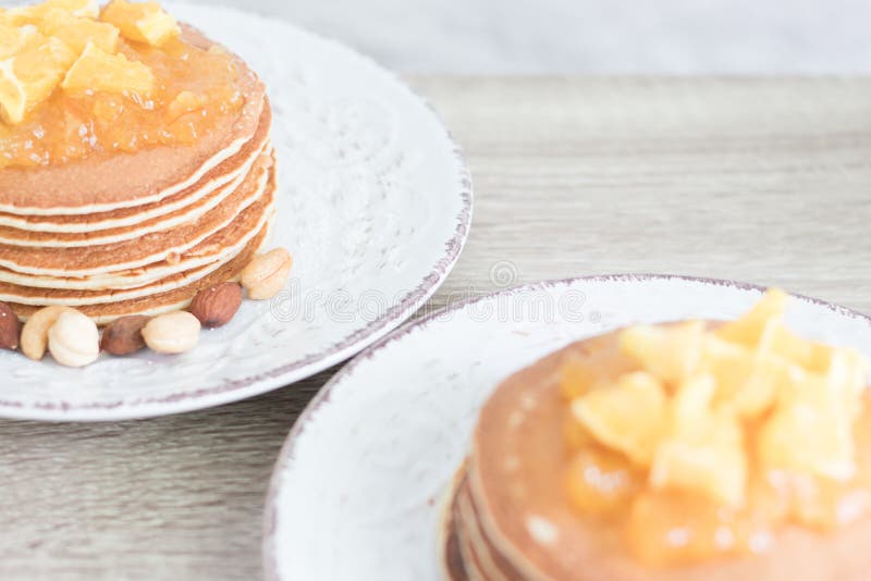 Two Pancakes Plates with Orange Jam and Nuts on Wooden Table. Closeup ...