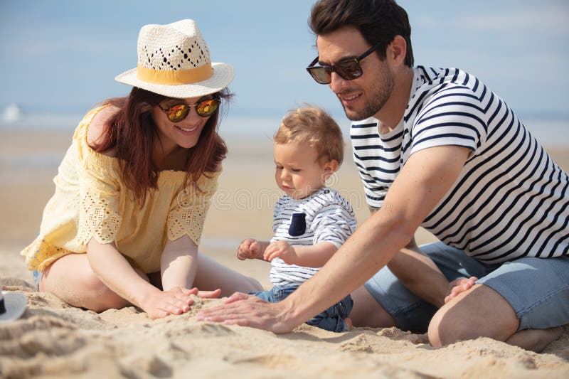 Two Parents and Their Toddler Playing Together in Sand Stock Photo ...