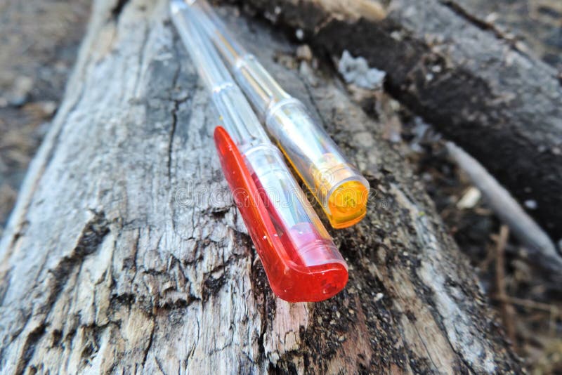 Two Pens Red and Yellow on a Rough Wood Surface Stock Image - Image of ...