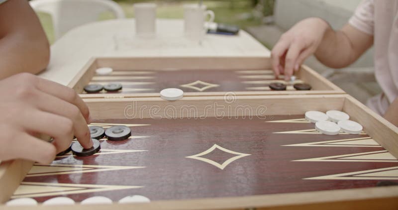 Two People Enjoying a Backgammon Game in a Bright Outdoor Setting with ...