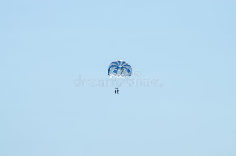 Two People Fly in Spain on a Parachute Against the Backdrop of the Sea ...