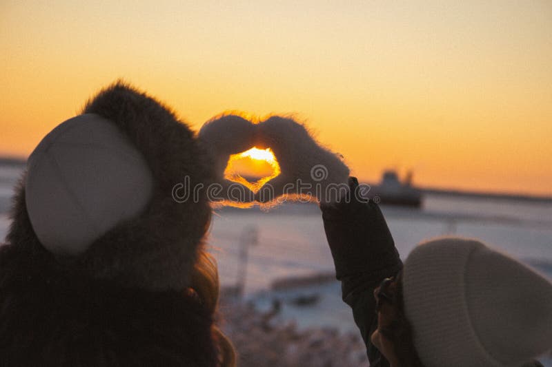 Two People Form a Heart Shape with Their Hands at Sunset Stock Photo ...