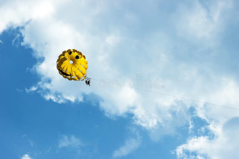 Two People are Gliding Using a Parachute on the Background of the Blue ...