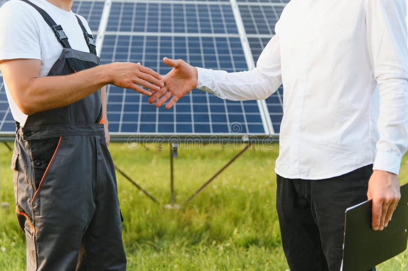 Two People Having a Shaking Hands Against Solar Panel after the ...