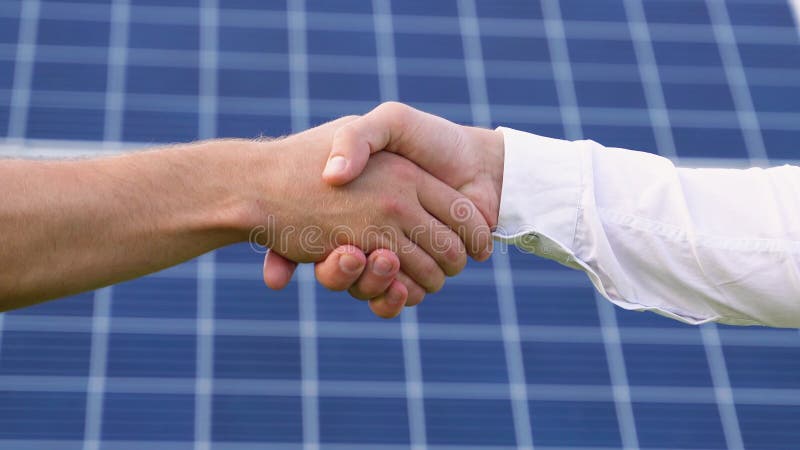 Two People Having a Shaking Hands Against Solar Panel after the ...
