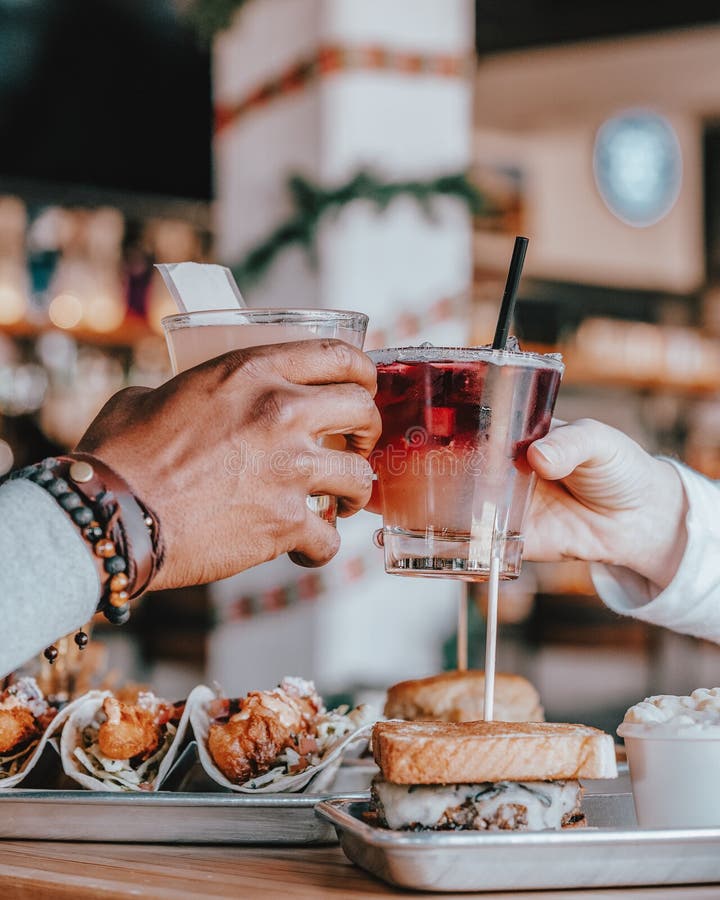 Two People Holding Refreshing Cold Drinks with Straws in Their Hands ...