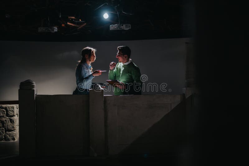 Two People Interacting in a Museum Exhibit Setting with Dim Ambient ...