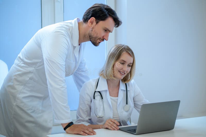Two People in Lab Coats Discussing Something and Looking Interested ...
